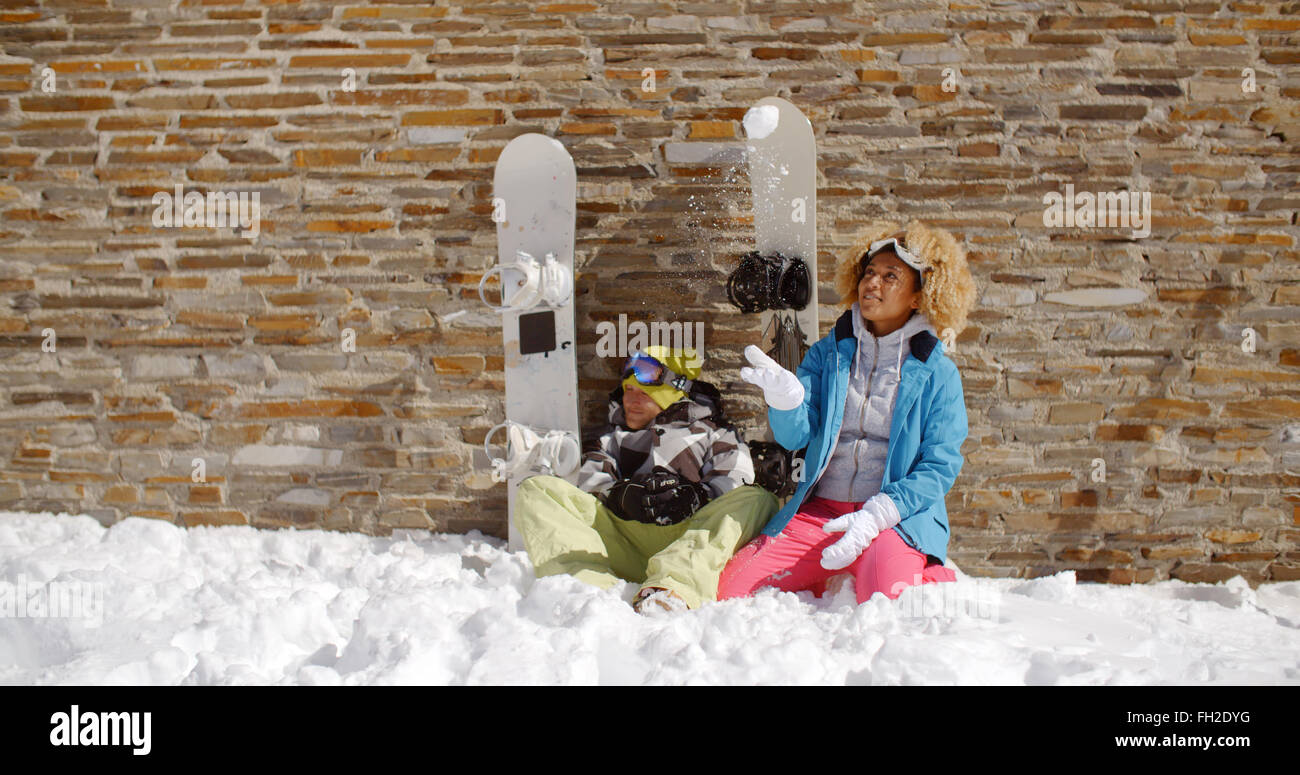 Snowboarding friends sitting in pile of snow Stock Photo - Alamy