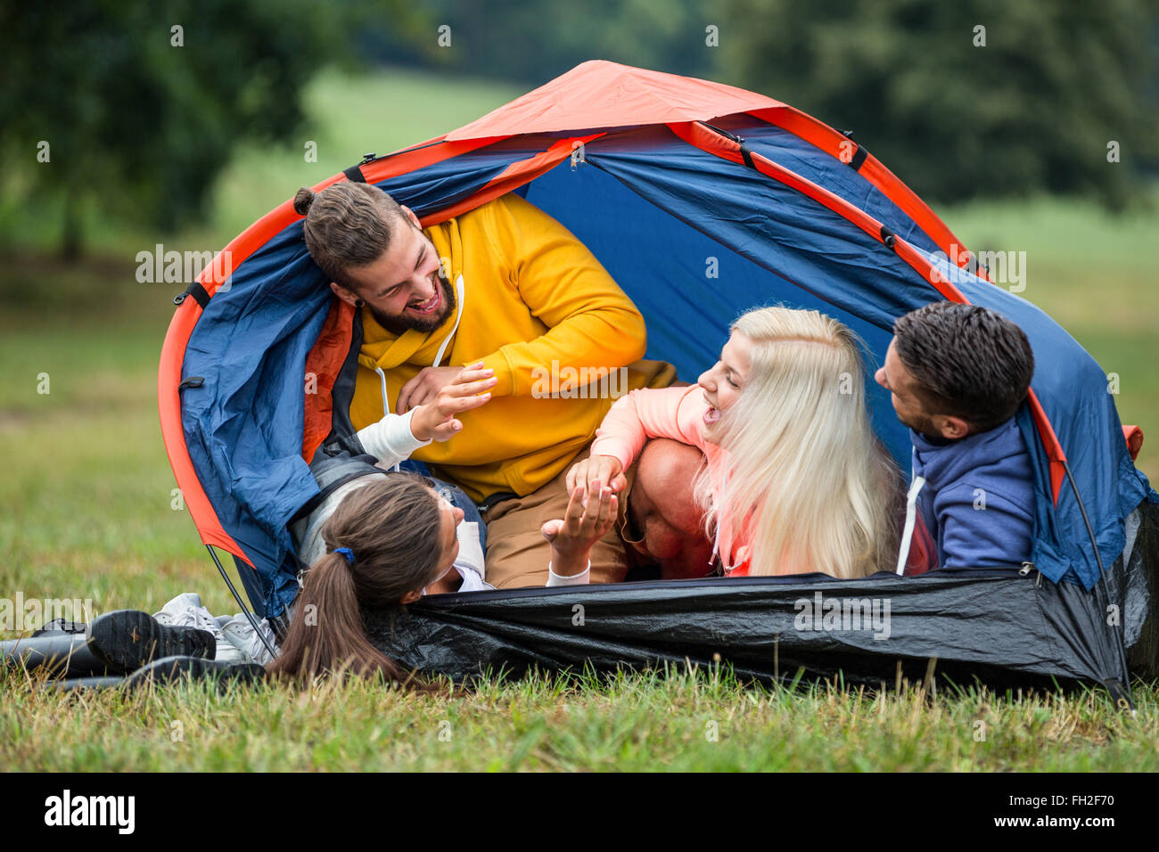 Happy friends in their tent Stock Photo - Alamy