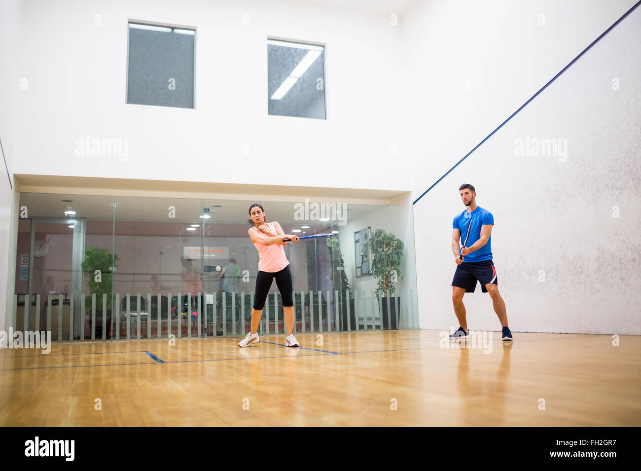 Couple playing a game of squash Stock Photo - Alamy