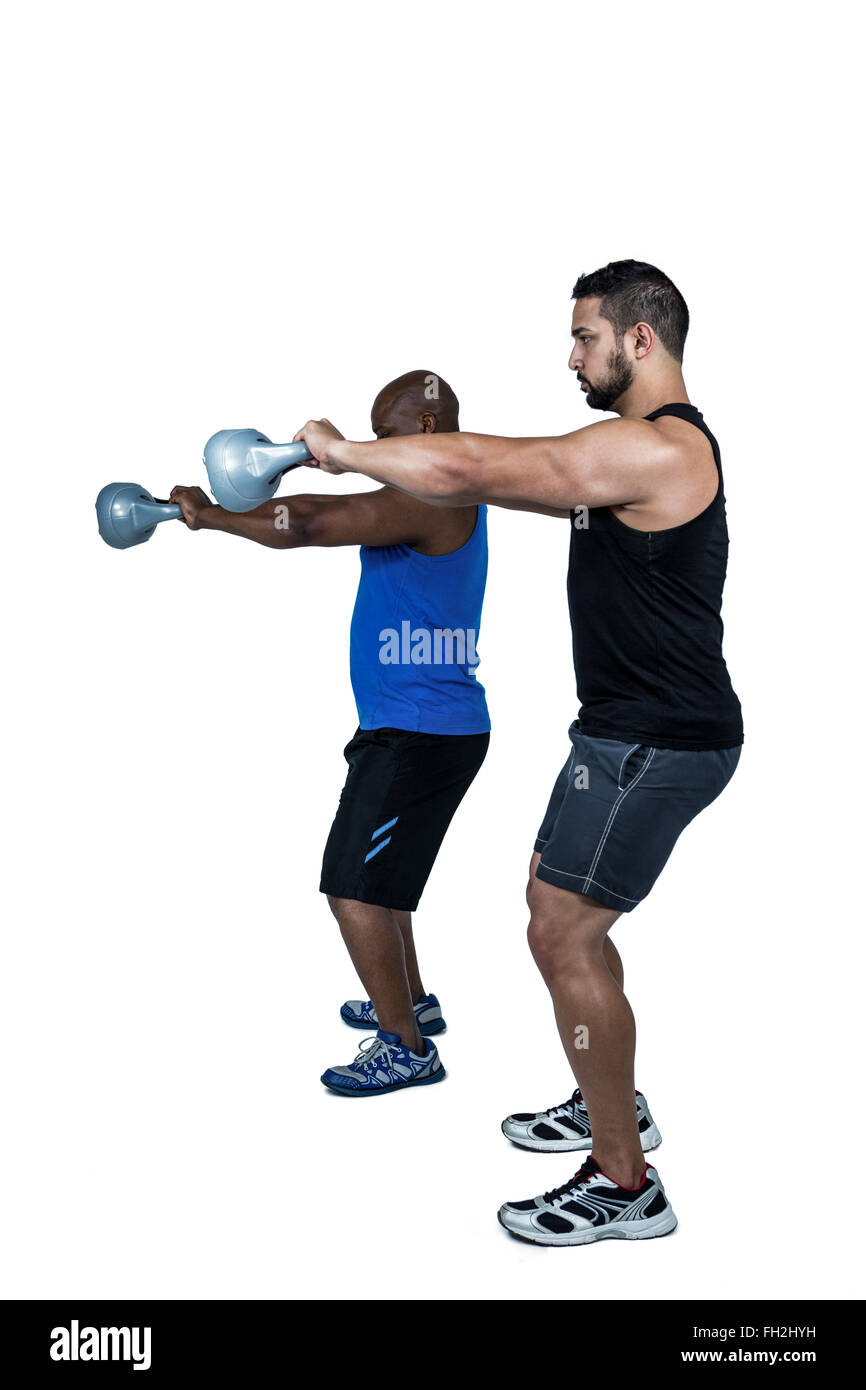 Strong friends lifting kettlebells together Stock Photo - Alamy