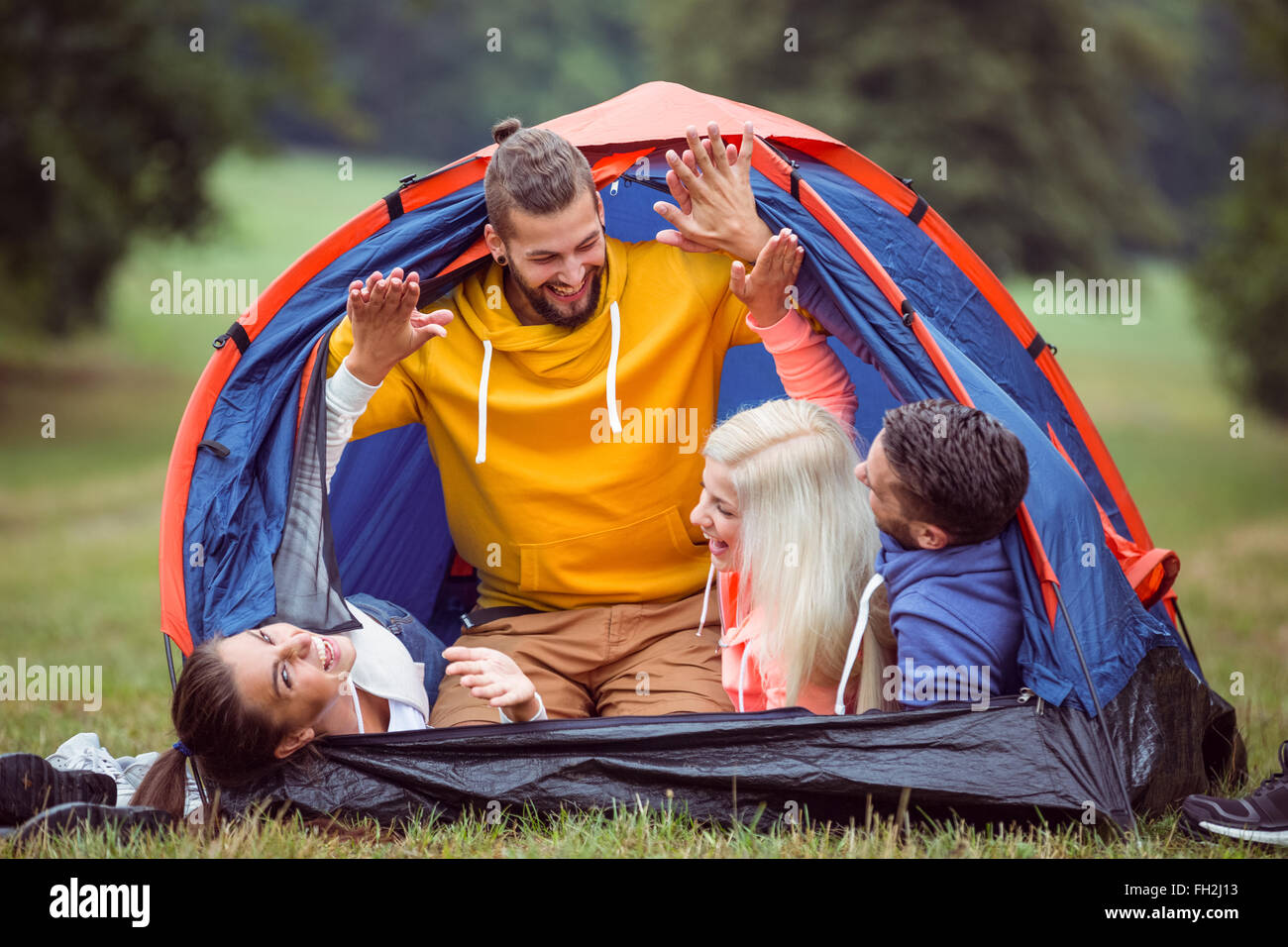 Happy friends in their tent Stock Photo - Alamy