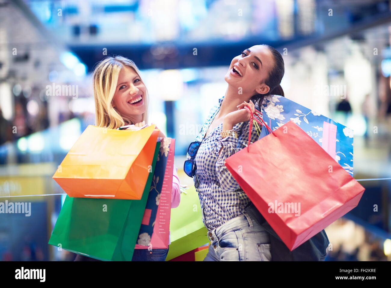 happy young girls in shopping mall Stock Photo - Alamy