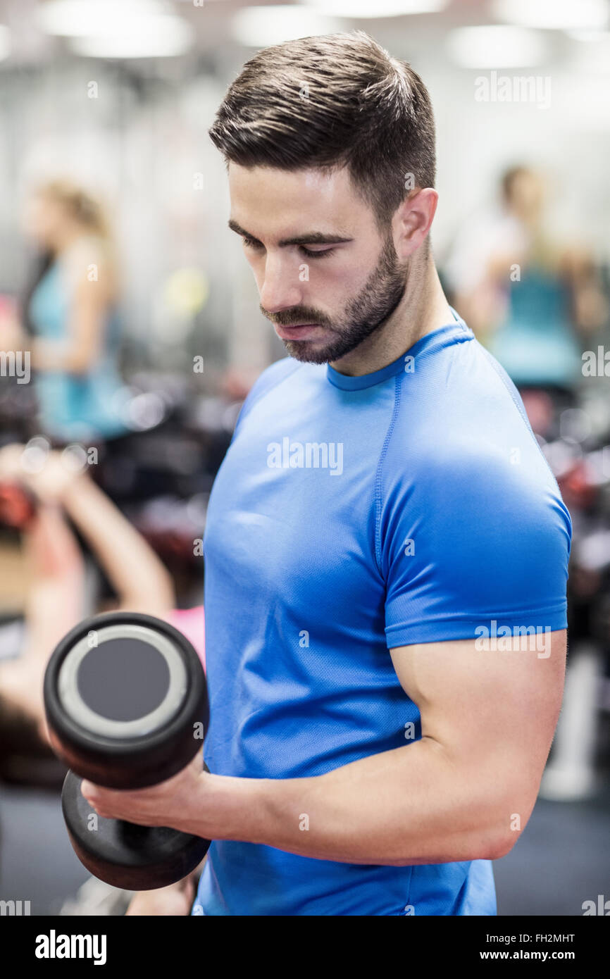 Fit man lifting heavy black dumbbell Stock Photo - Alamy