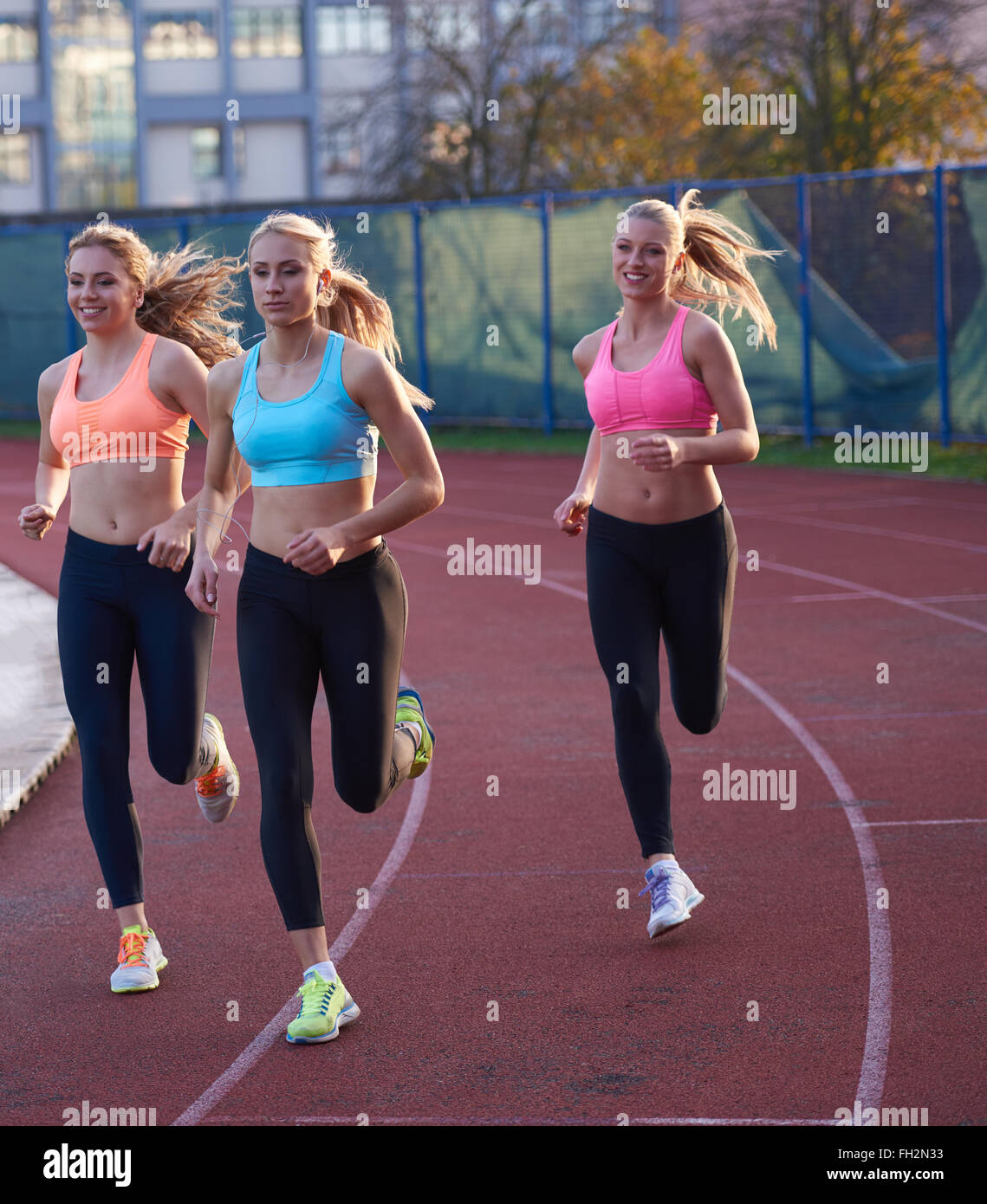 athlete woman group running on athletics race track Stock Photo - Alamy