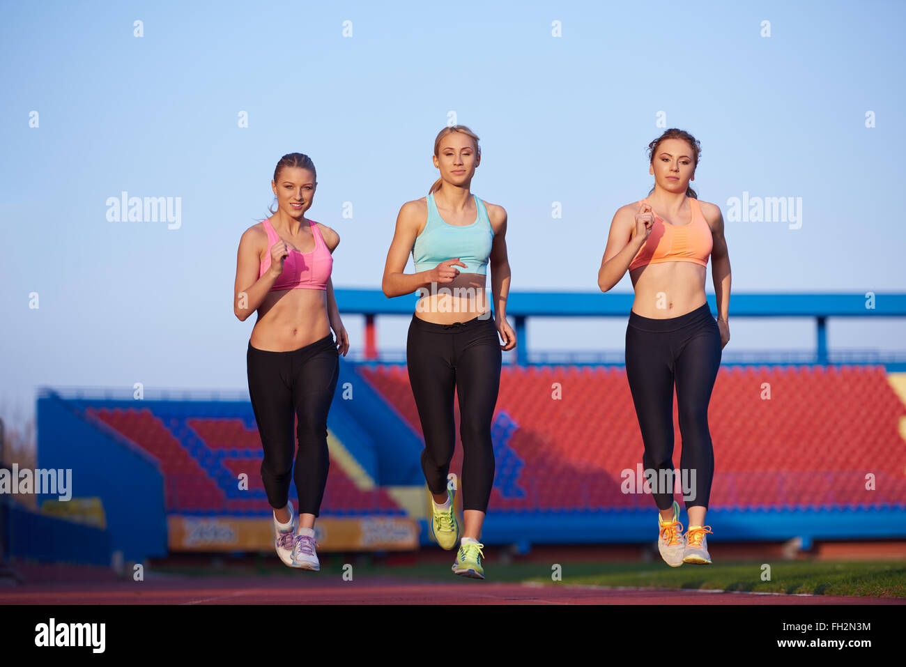 athlete woman group running on athletics race track Stock Photo - Alamy