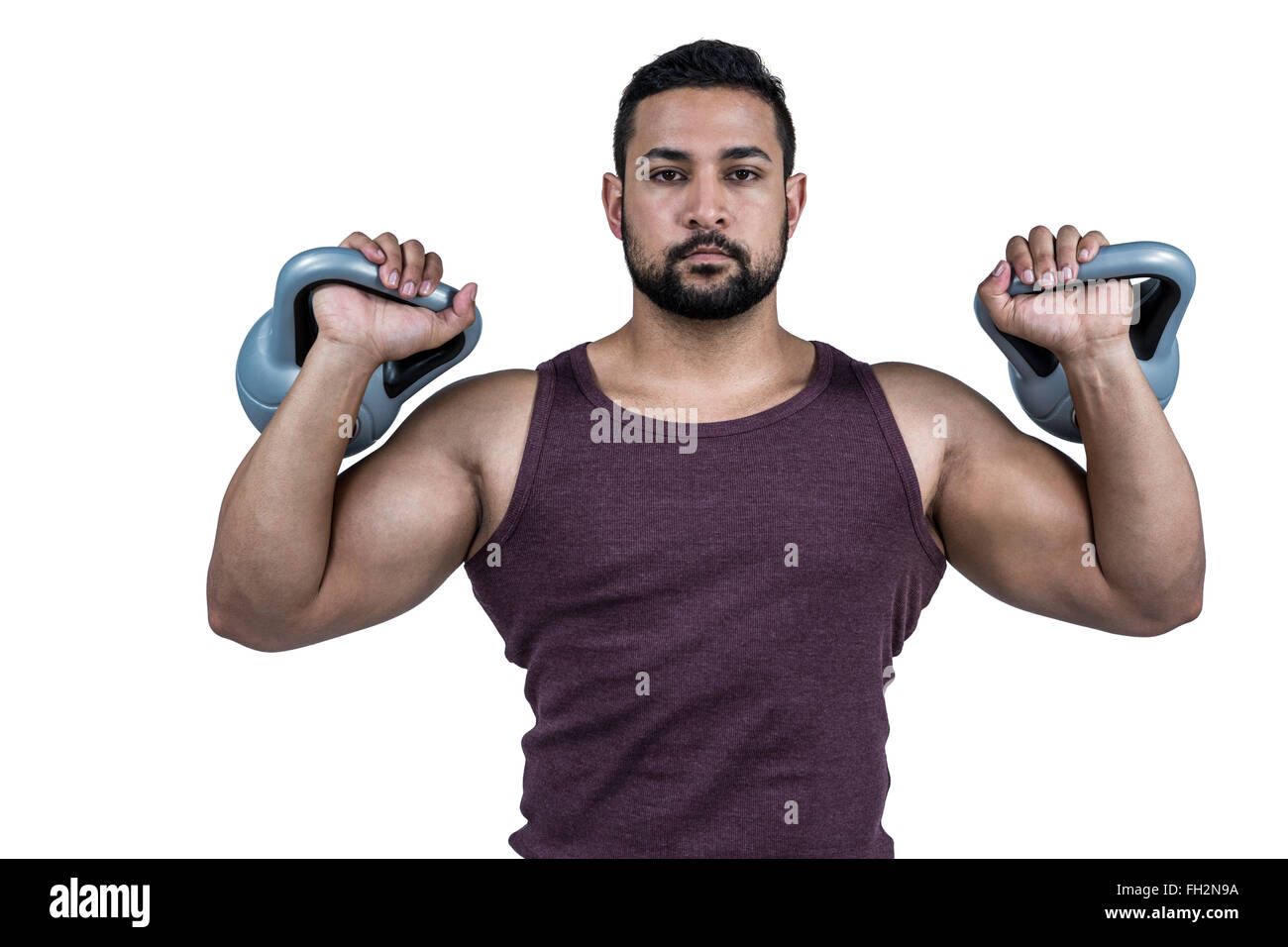Muscular serious man lifting kettlebells Stock Photo - Alamy