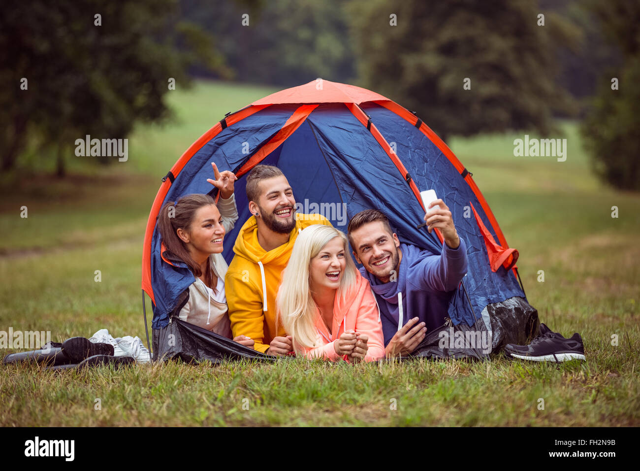 Happy friends lying in their tent taking selfie Stock Photo - Alamy
