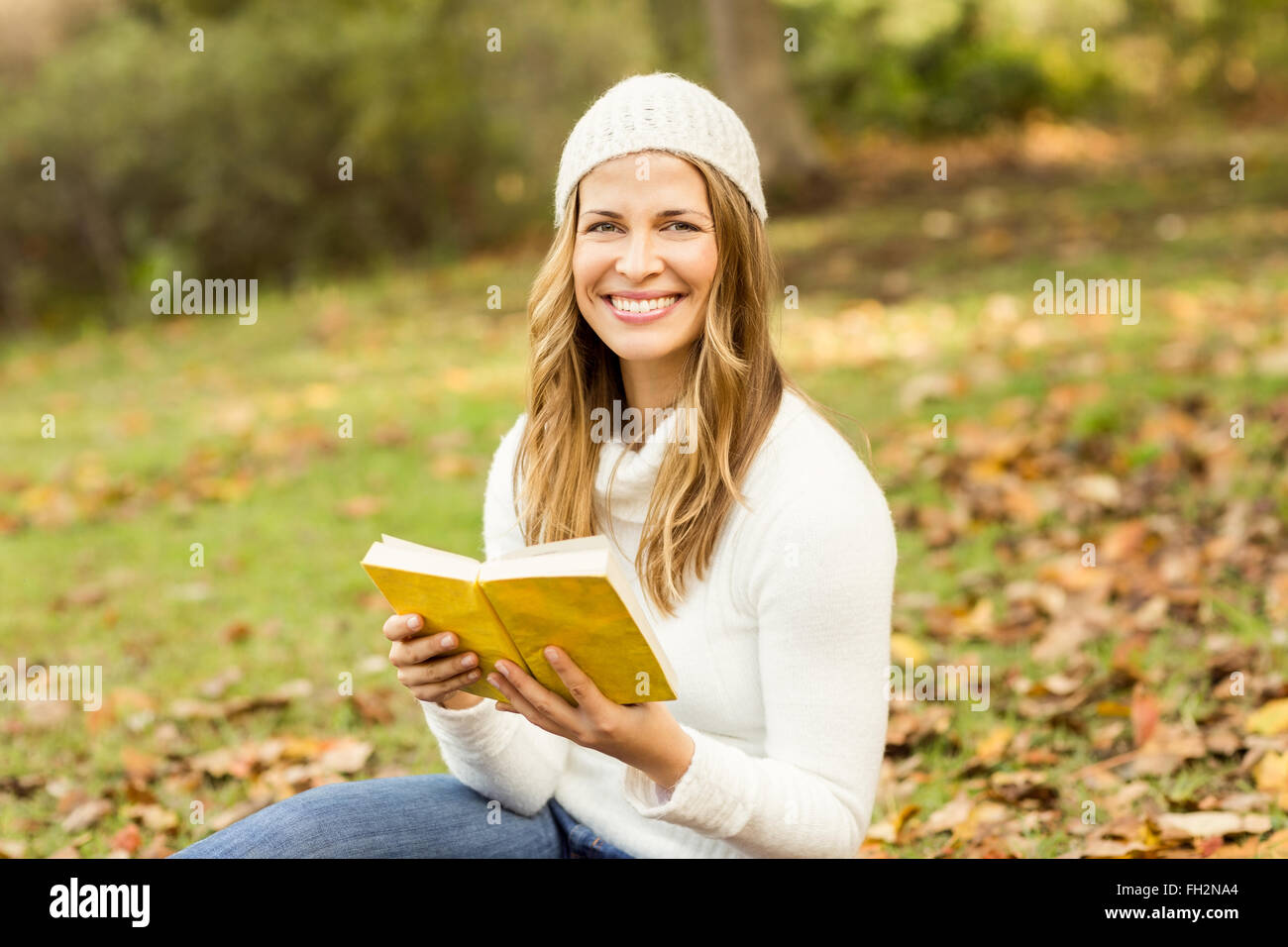 Portrait of a smiling pretty woman reading a book Stock Photo - Alamy
