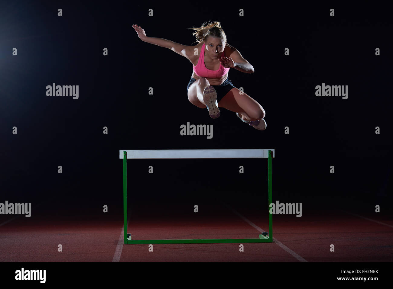 woman athlete jumping over a hurdles Stock Photo - Alamy