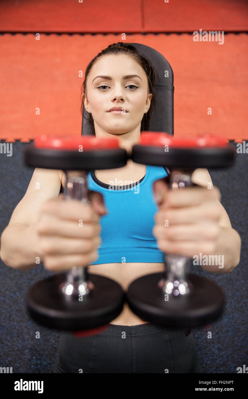 Smiling woman lifting dumbbells while lying down Stock Photo - Alamy
