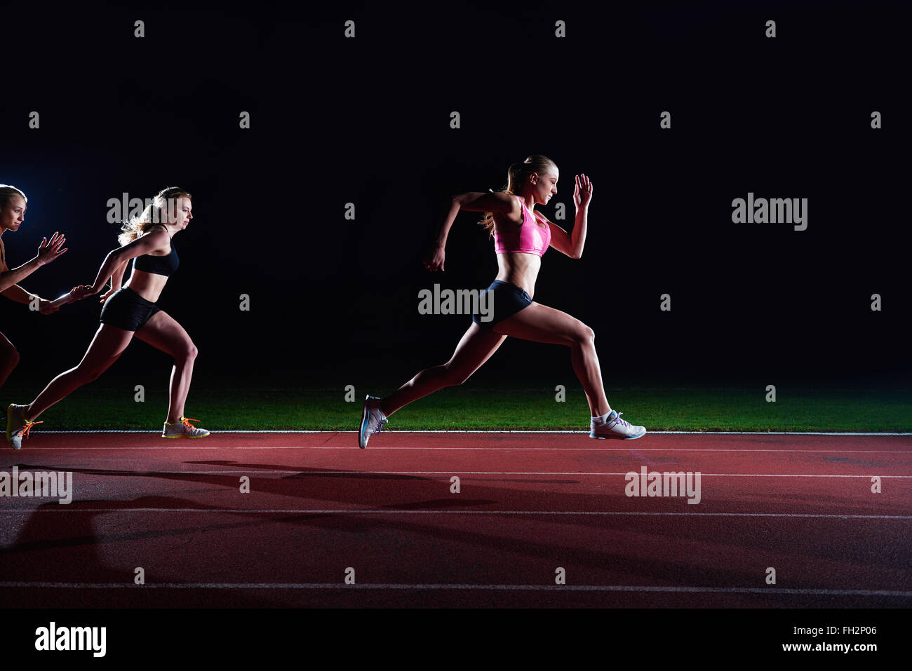 athletic runners passing baton in relay race Stock Photo - Alamy