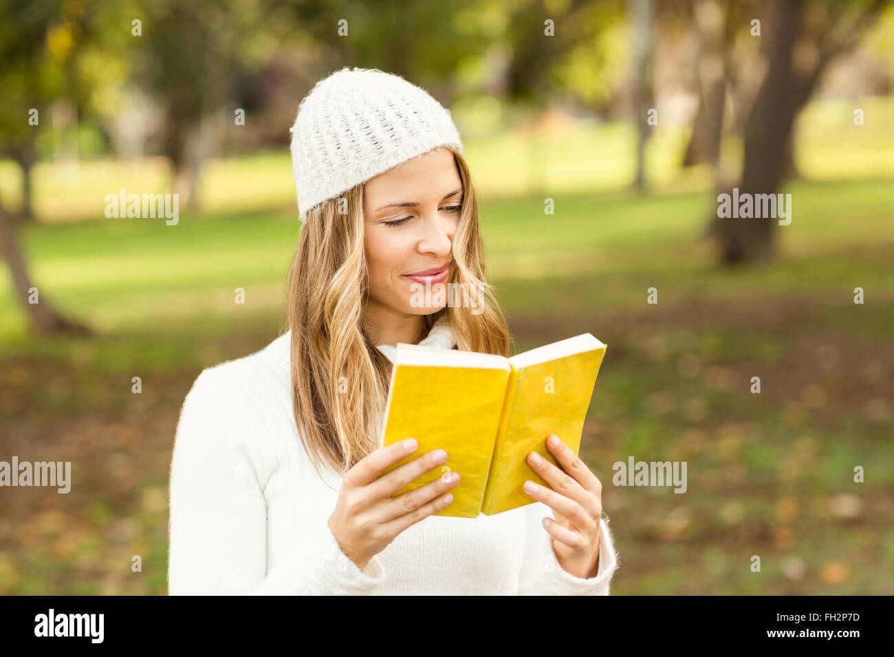 Smiling pretty woman reading a book Stock Photo - Alamy