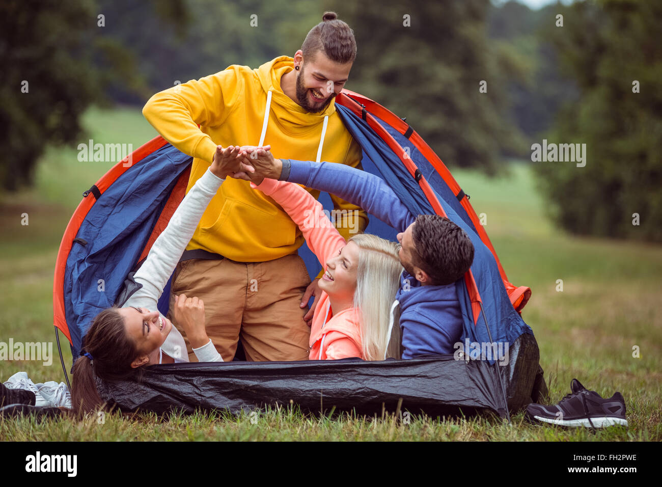 Smiling friends hike tent camping hi-res stock photography and images ...