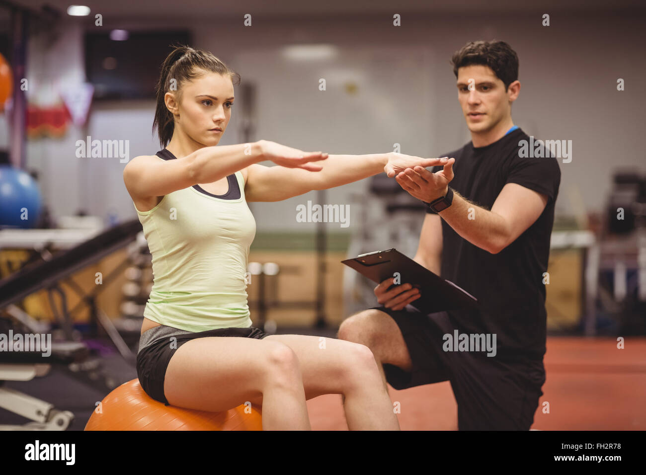 Fit woman working out with trainer Stock Photo - Alamy