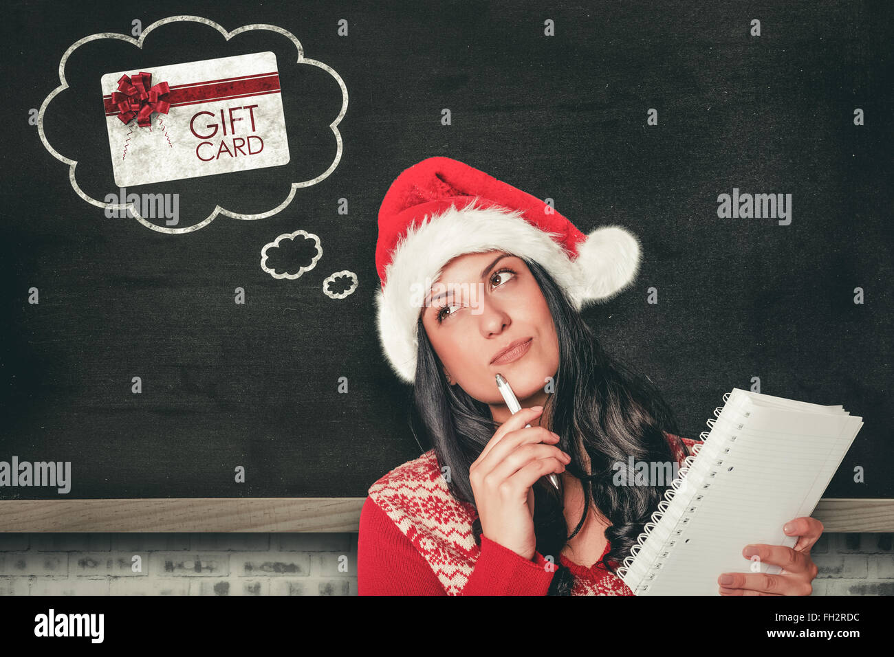 Composite image of woman thinking what to write Stock Photo - Alamy