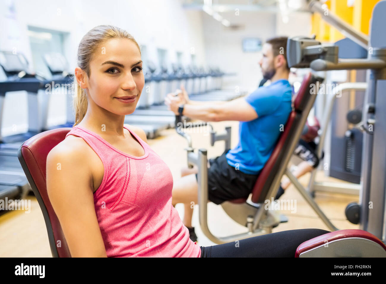 Fit people using weights machines Stock Photo - Alamy