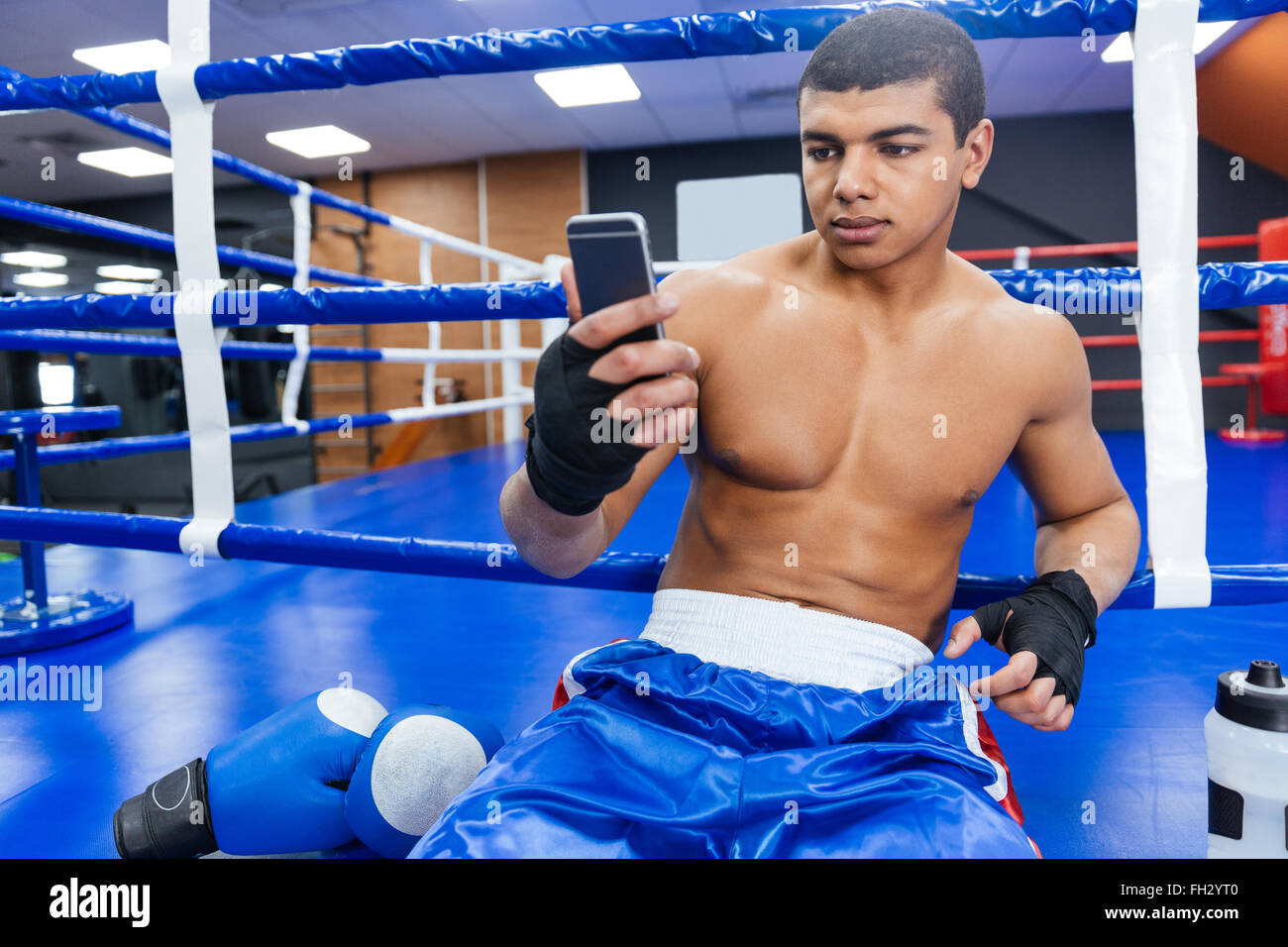 Male boxer using smartphone Stock Photo - Alamy
