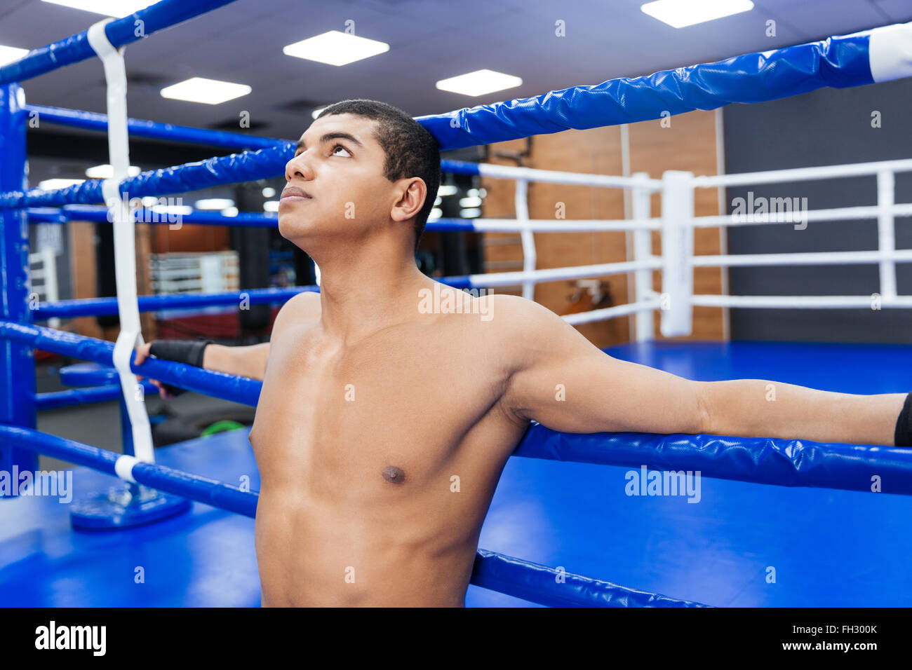 Pensive male boxer standing in gym and looking up Stock Photo - Alamy