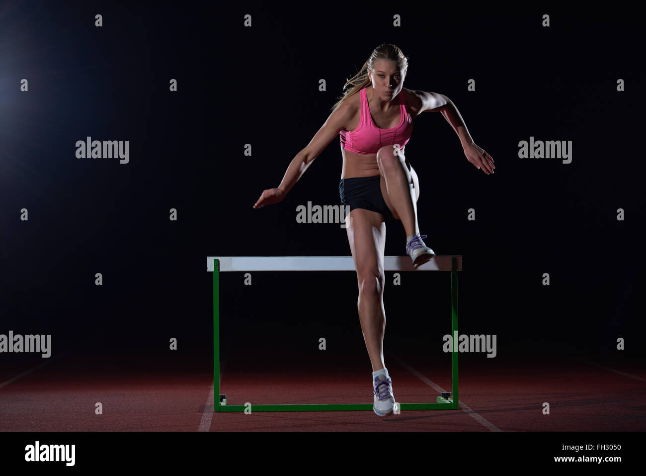 woman athlete jumping over a hurdles Stock Photo - Alamy