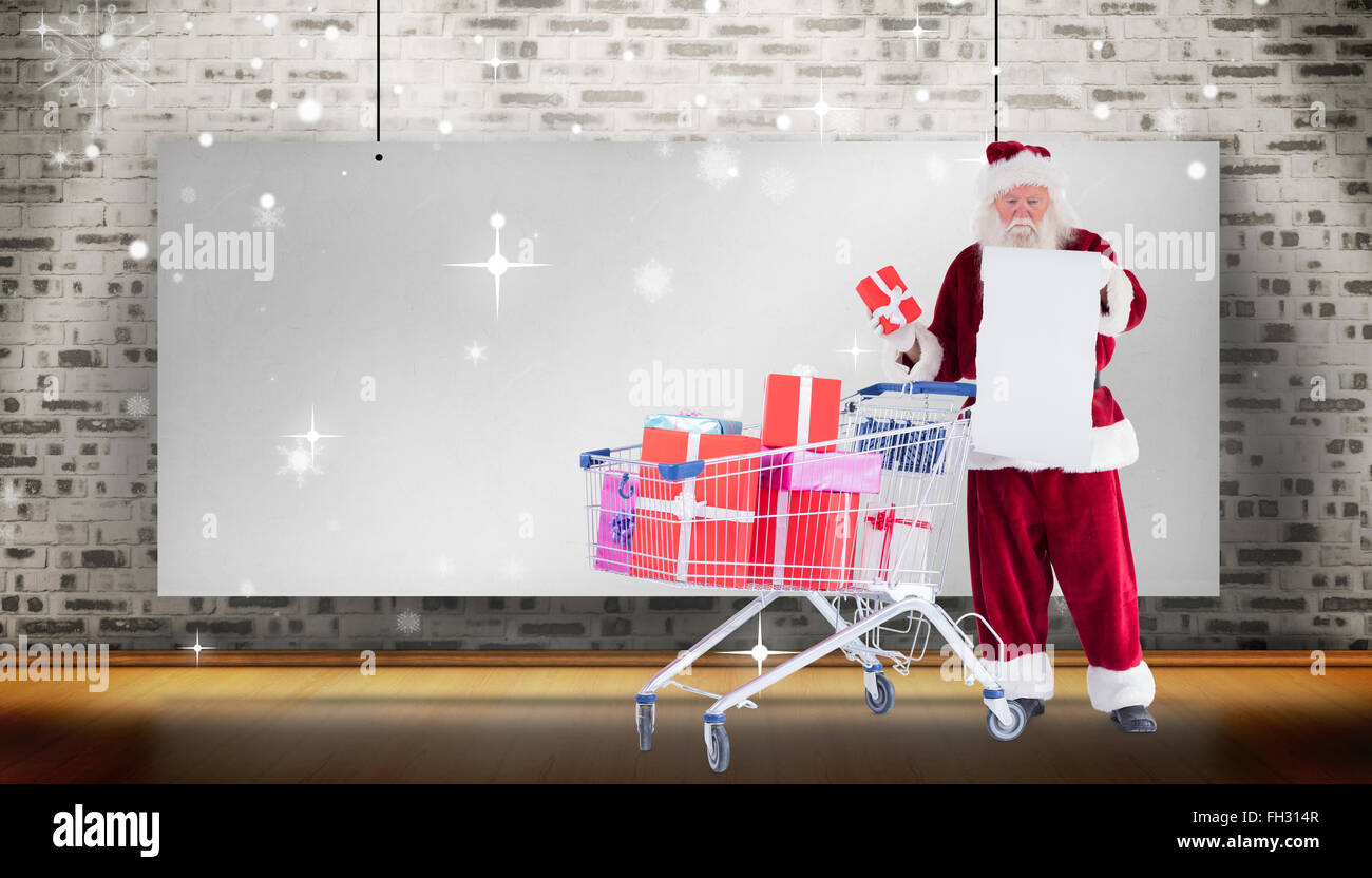 Composite image of santa delivering gifts from cart Stock Photo - Alamy