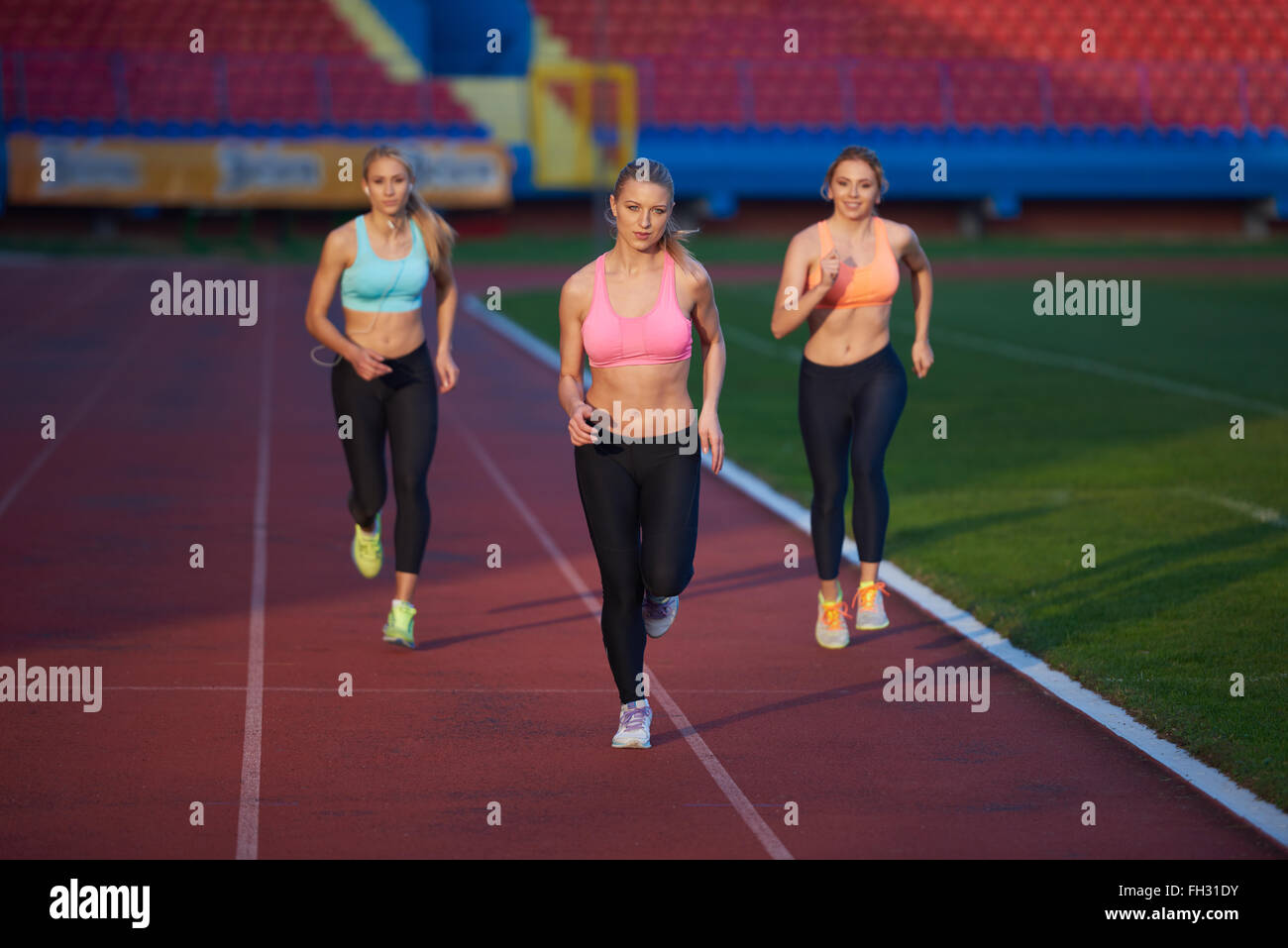athlete woman group running on athletics race track Stock Photo - Alamy