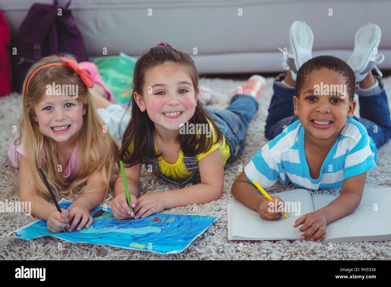 Smiling kids drawing pictures on paper Stock Photo - Alamy