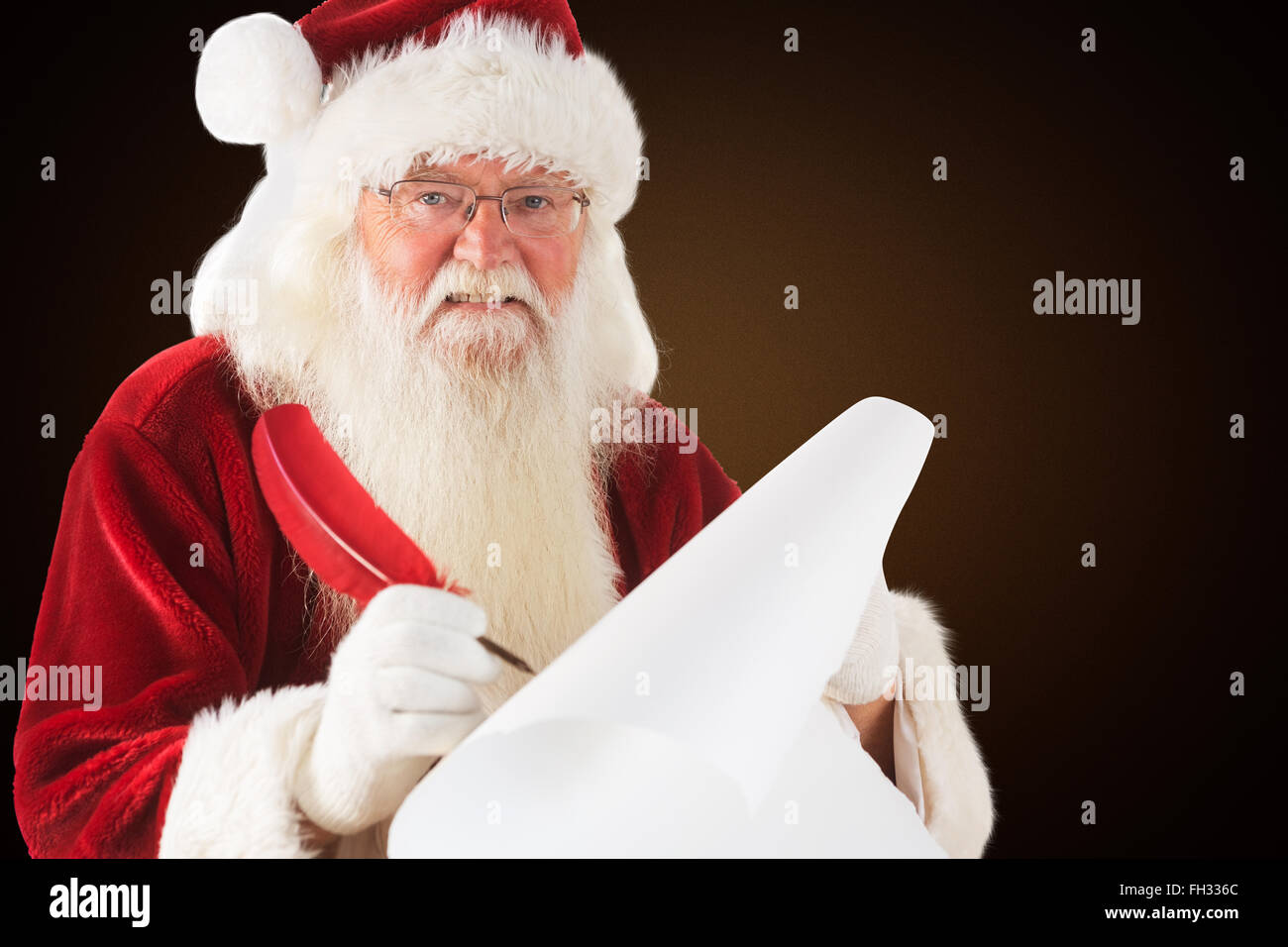 Composite image of santa claus writing on scroll Stock Photo - Alamy