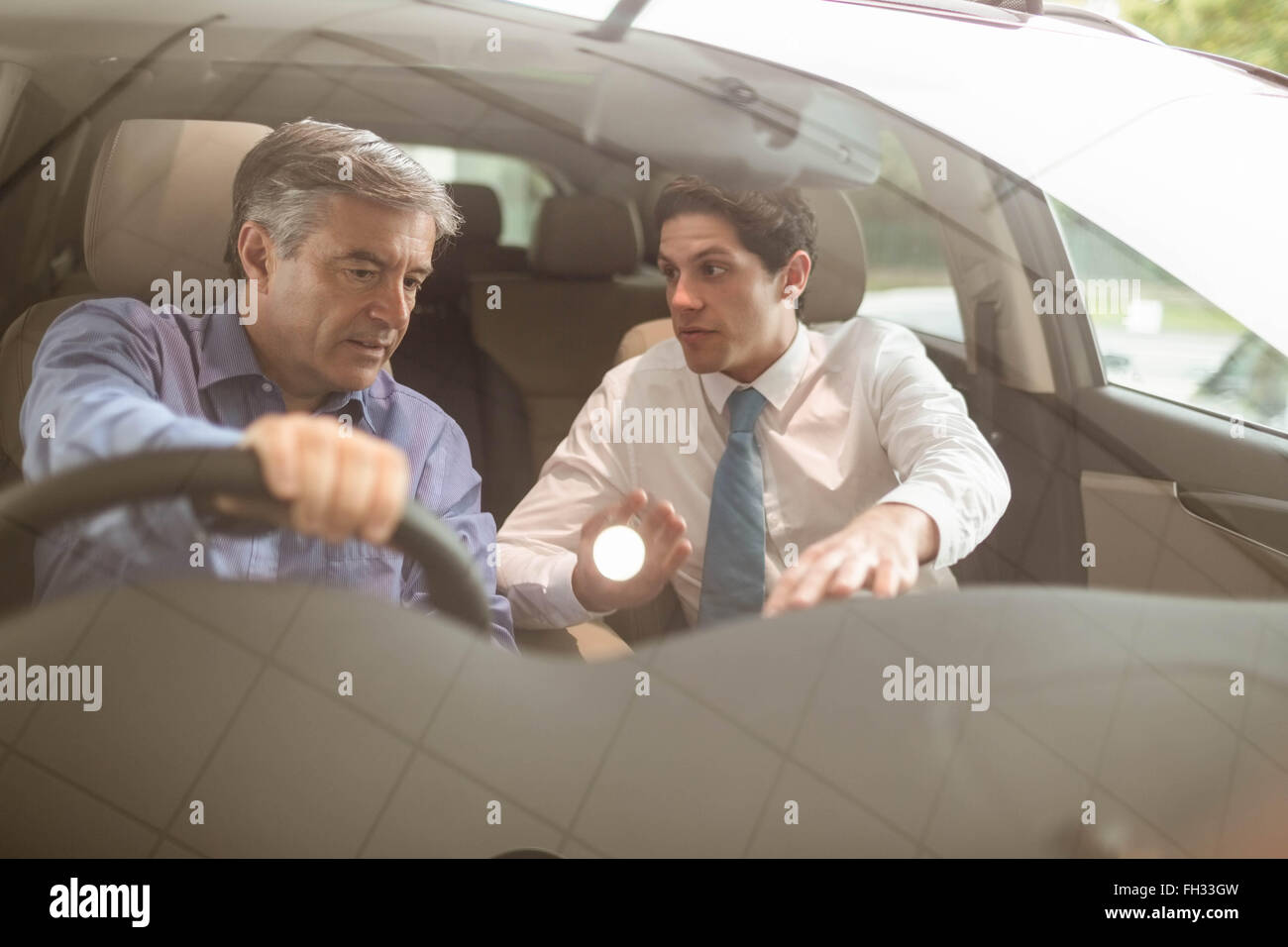 Businessman pointing a car interior Stock Photo - Alamy