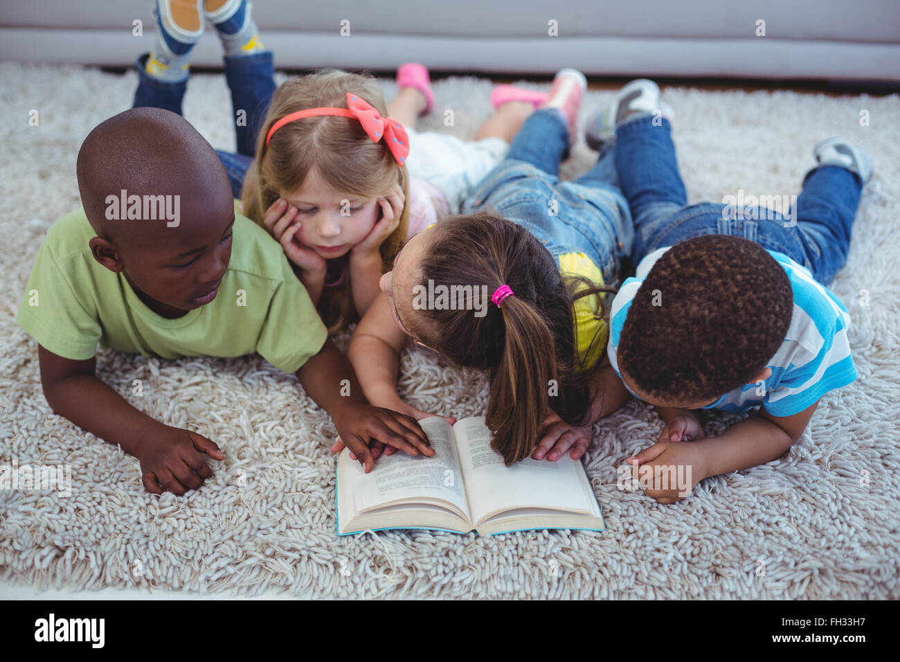 Happy kids reading a book together Stock Photo - Alamy
