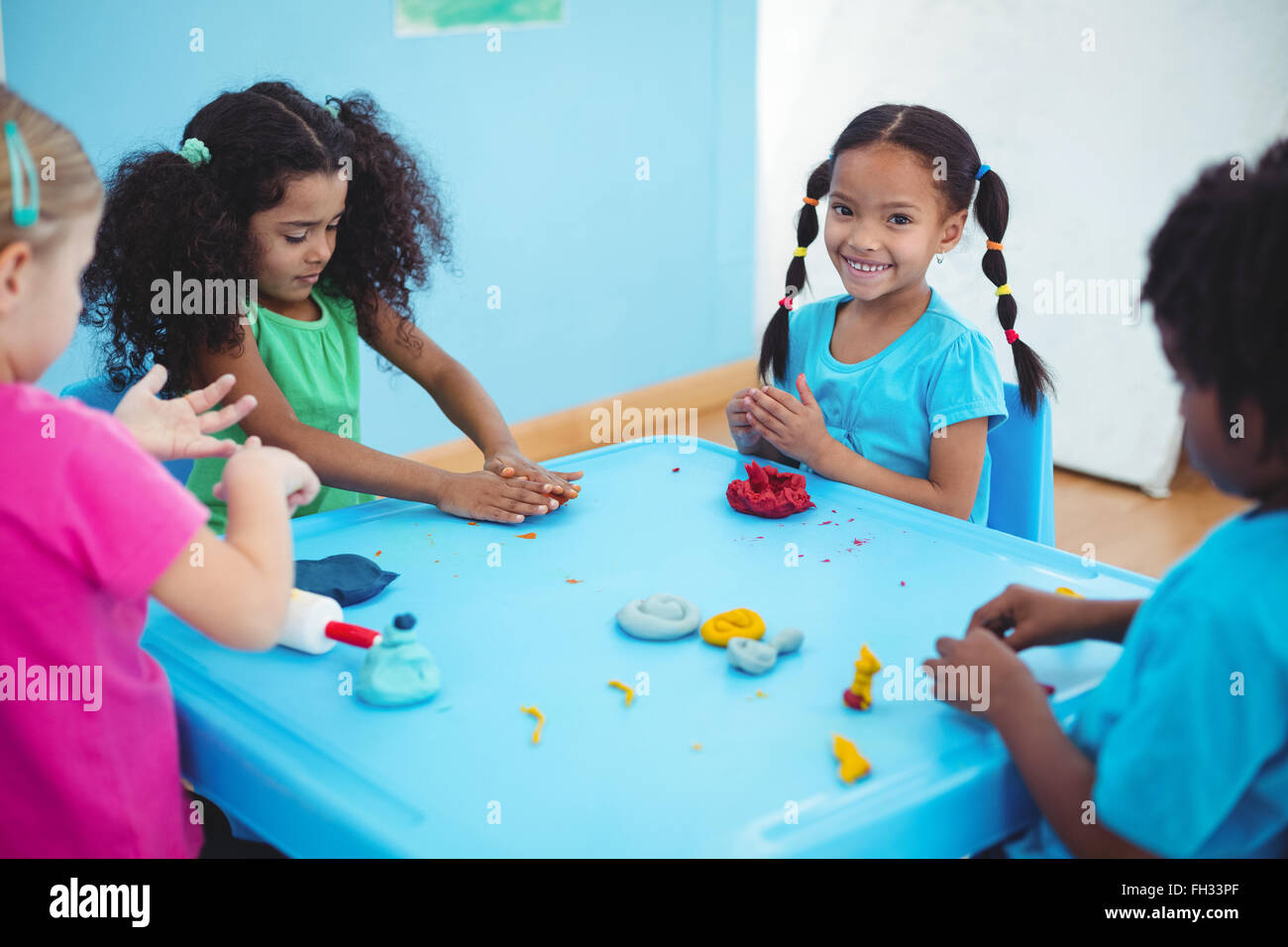 Smiling girls playing with modelling clay Stock Photo - Alamy
