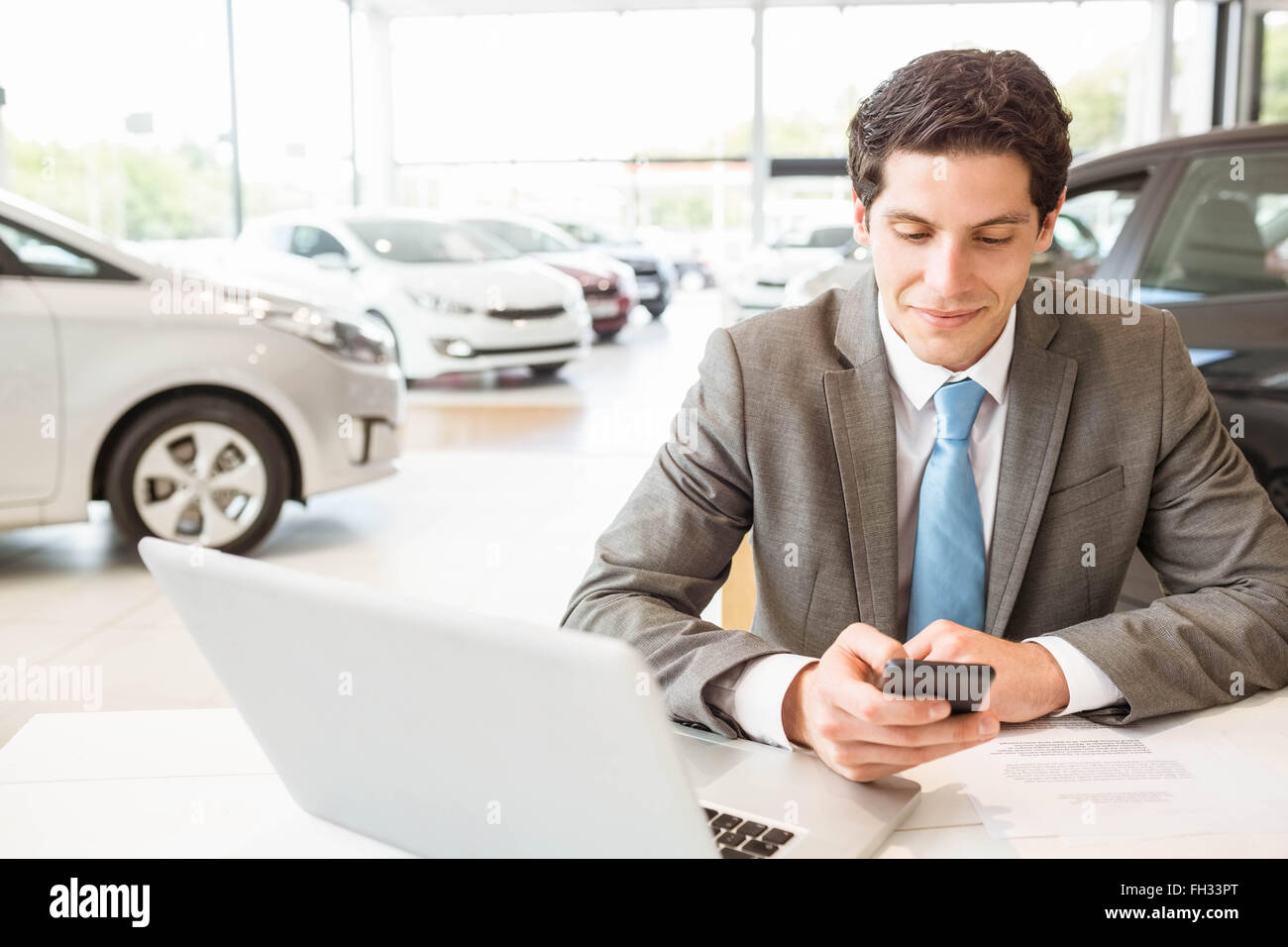Smiling salesman having a phone call Stock Photo - Alamy
