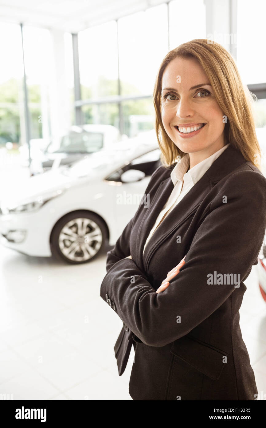 Smiling saleswoman standing with arms crossed Stock Photo - Alamy