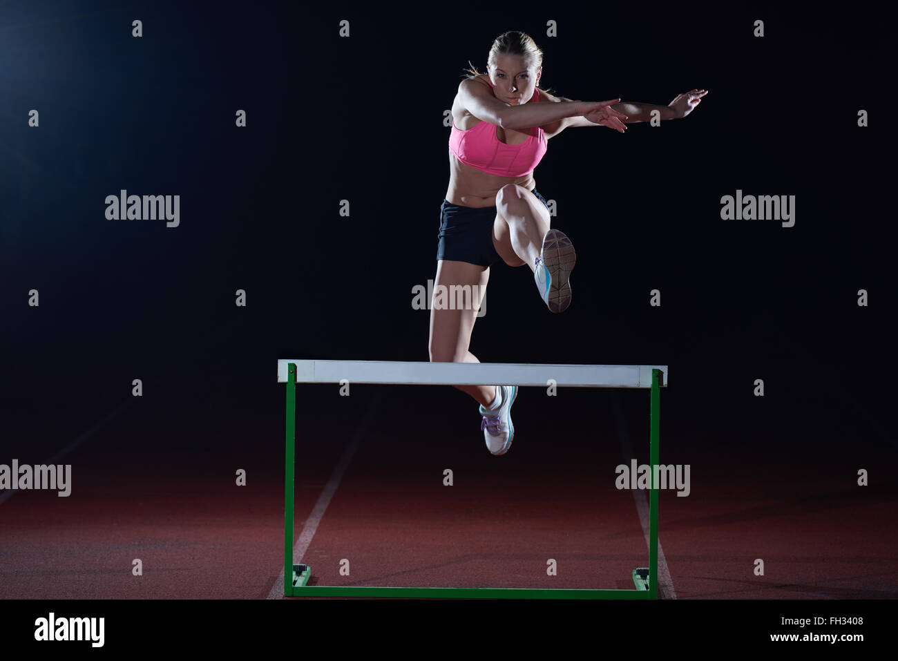 woman athlete jumping over a hurdles Stock Photo - Alamy