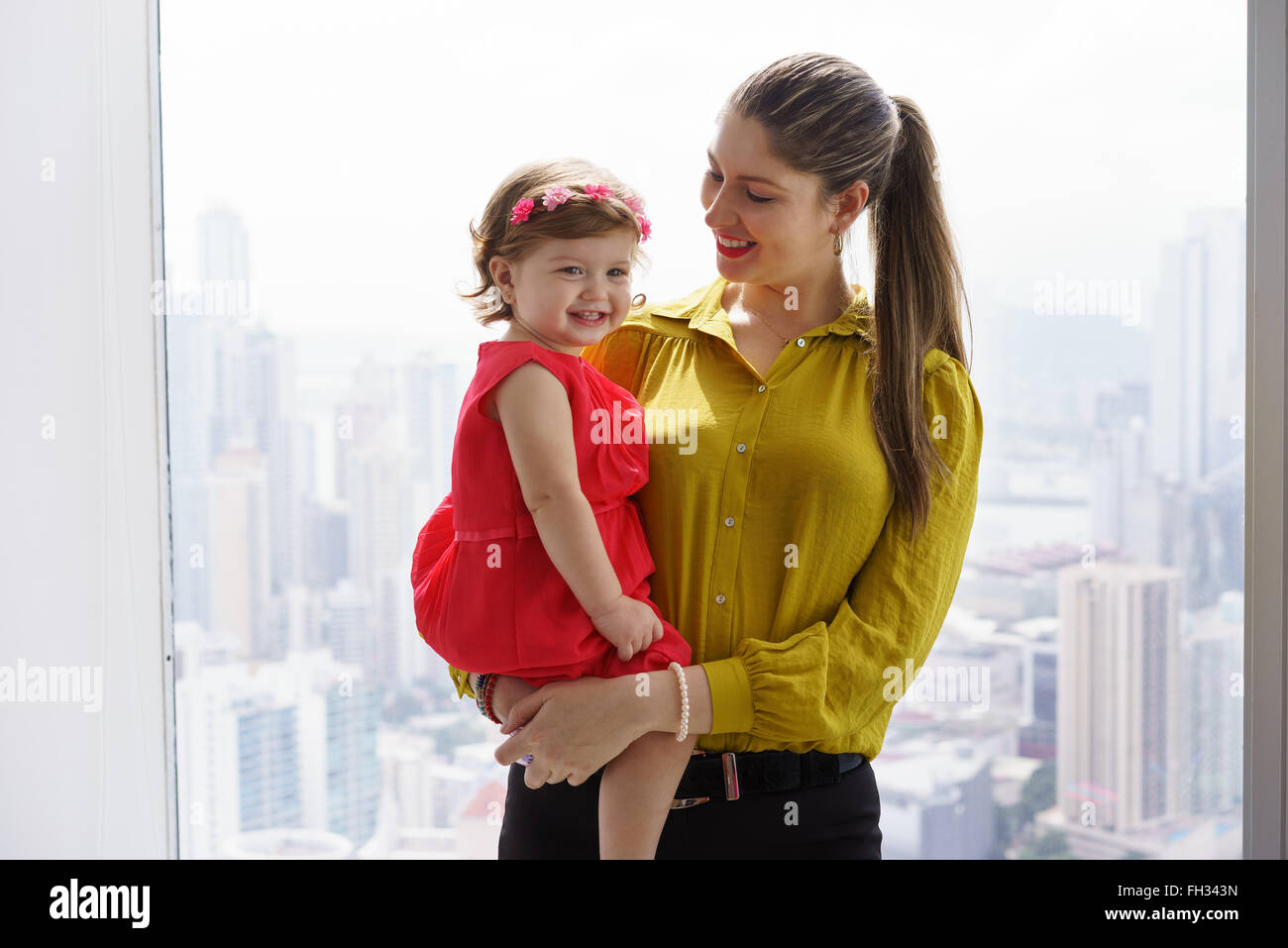 White businesswoman with little daughter in office. The executive mom ...