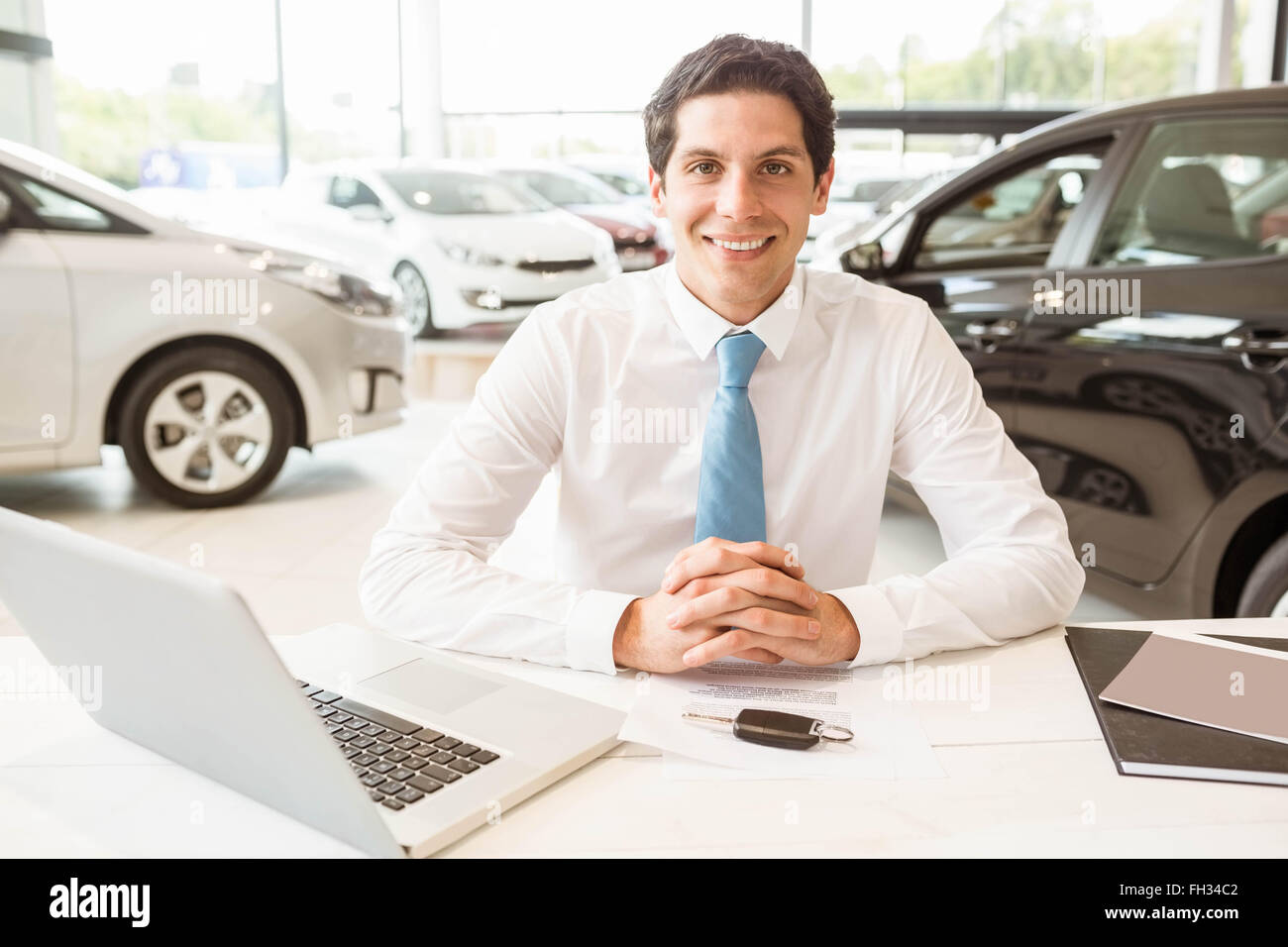 Smiling salesman behind his desk Stock Photo - Alamy