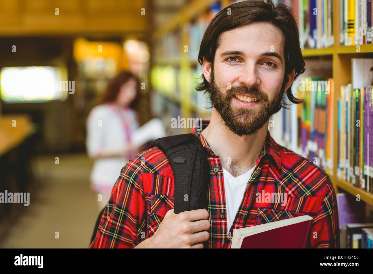 Smiling student in the library Stock Photo - Alamy