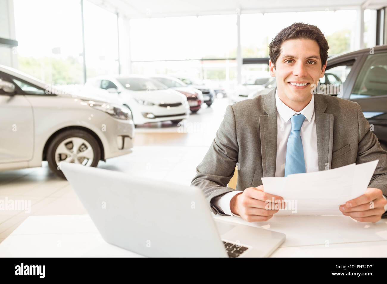 Smiling salesman reading a document Stock Photo - Alamy