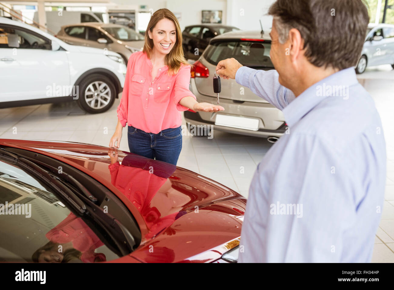 Smiling businessman giving car key to happy customer Stock Photo - Alamy