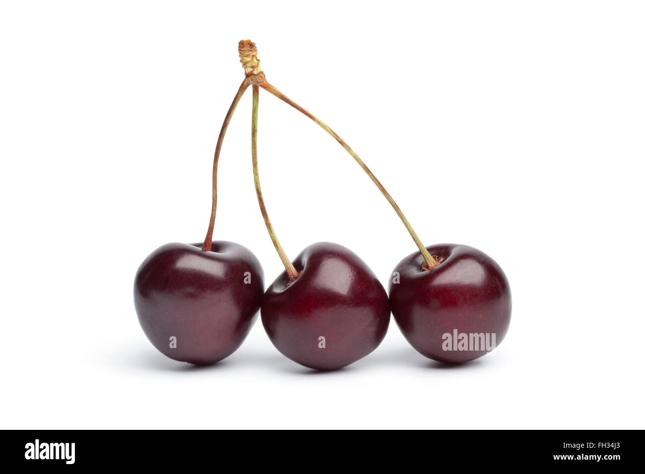 Red cherry triplets on stalks on white background Stock Photo - Alamy