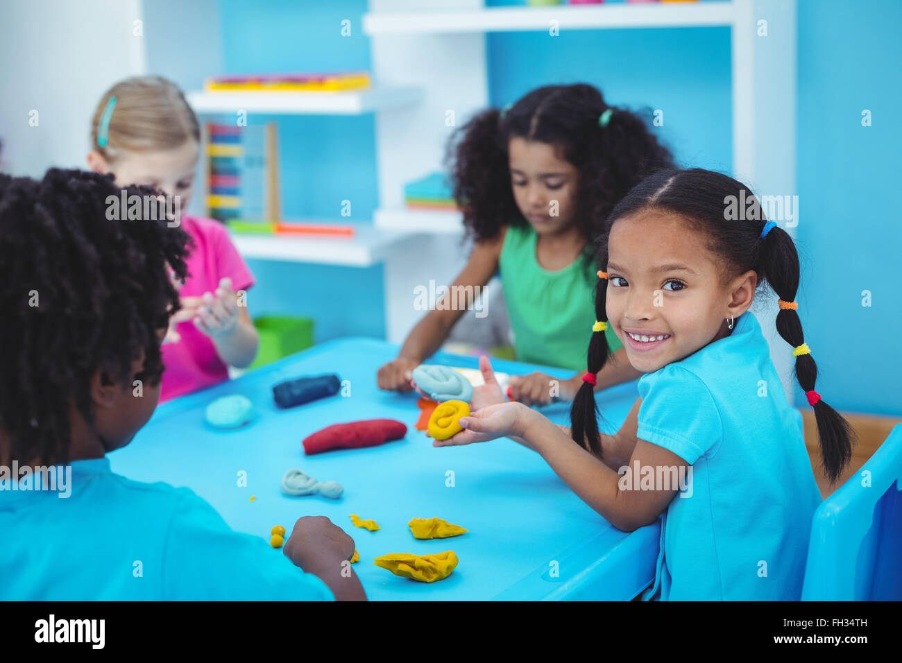 Smiling kids using modelling clay Stock Photo - Alamy