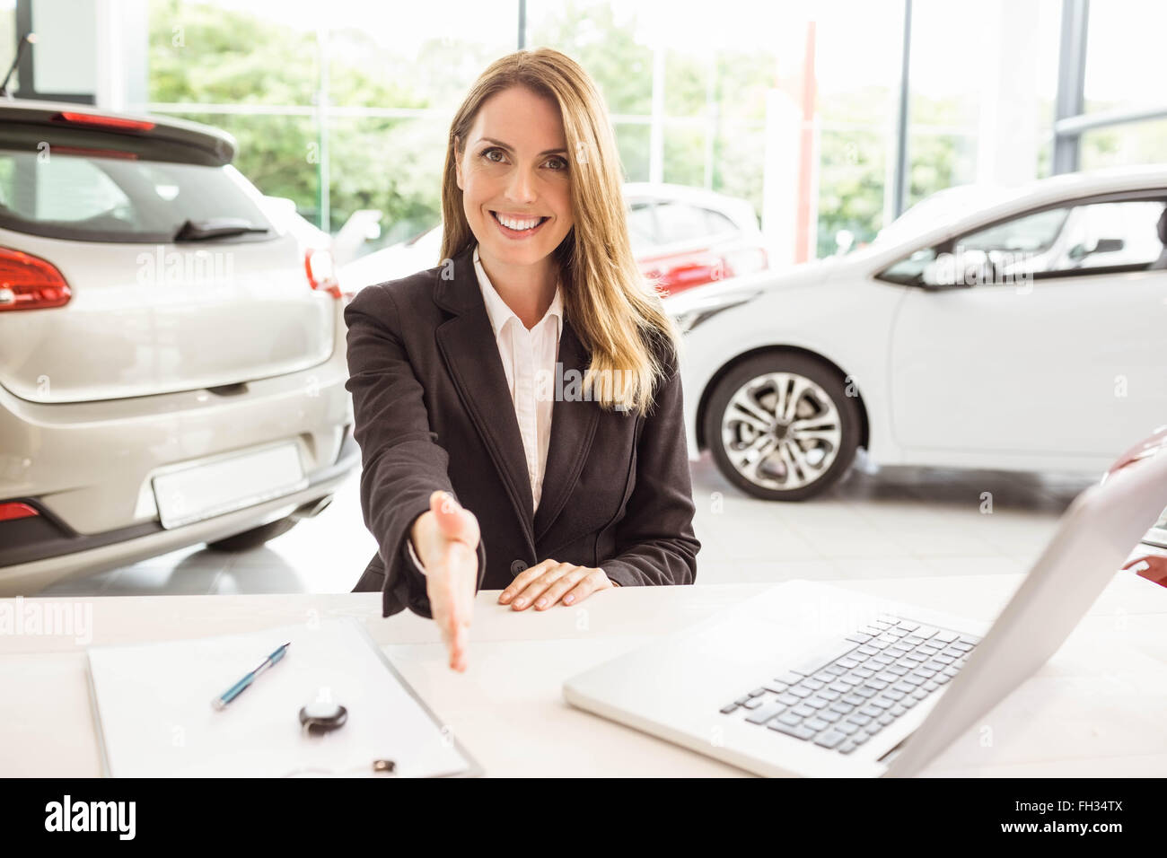 Smiling saleswoman ready to shake hand Stock Photo - Alamy