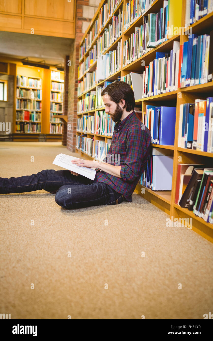 Student reading book in library on floor Stock Photo - Alamy