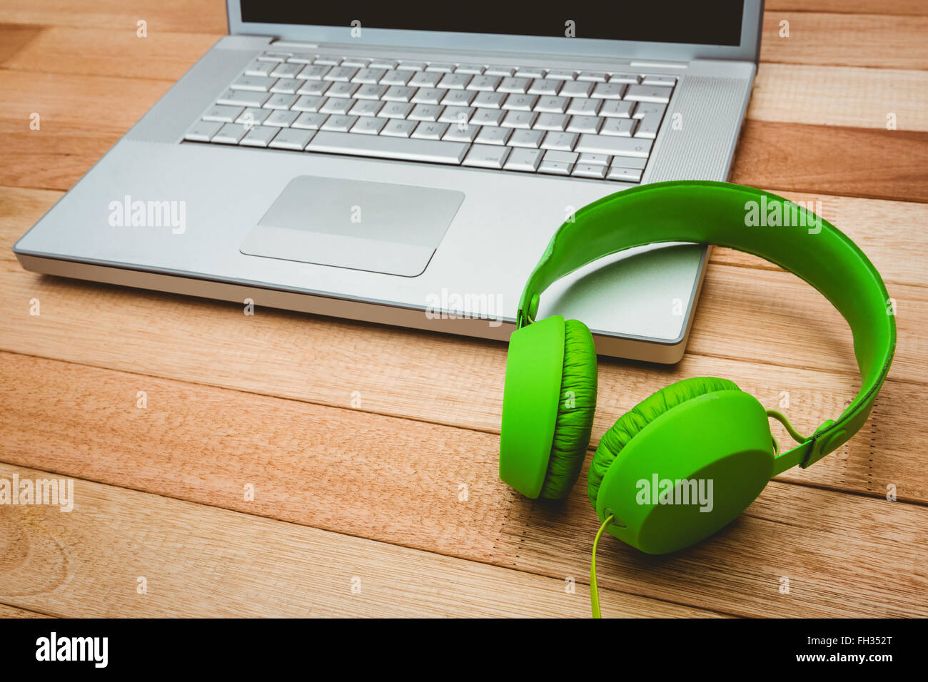 View of a grey laptop with a green headphone Stock Photo - Alamy