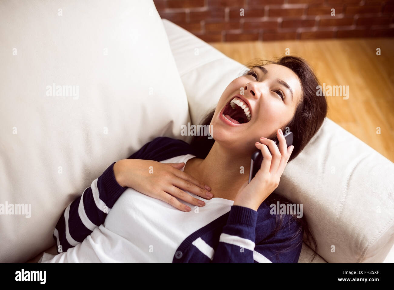 Asian woman laughing on the phone Stock Photo - Alamy