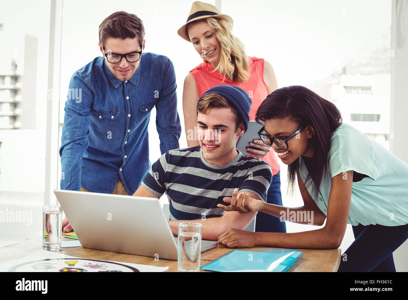 Creative business team working hard together on laptop Stock Photo - Alamy