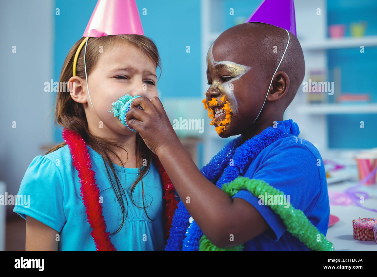 Smiling kids with icing on their faces Stock Photo - Alamy