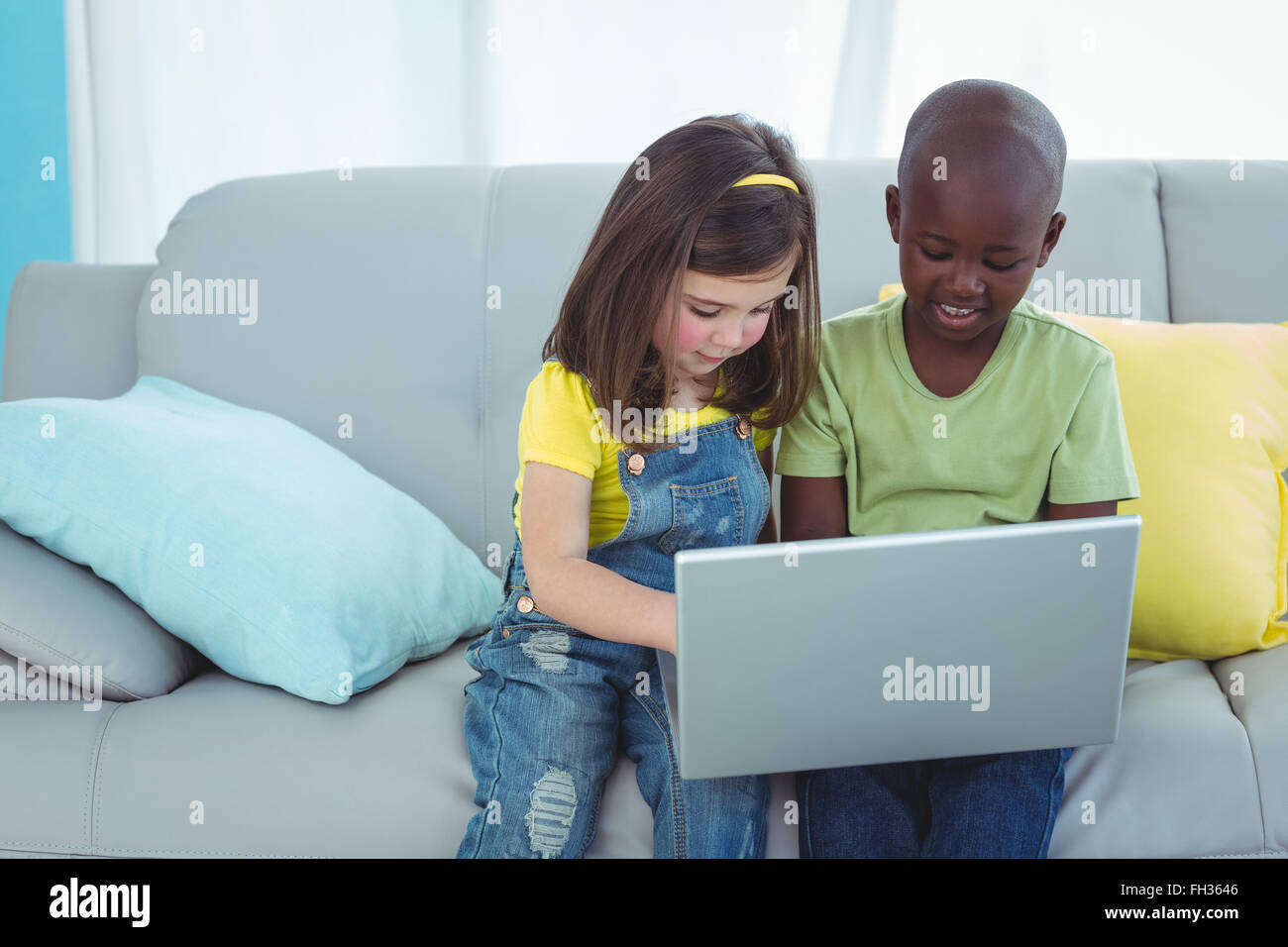 Smiling girl and boy using a laptop Stock Photo - Alamy