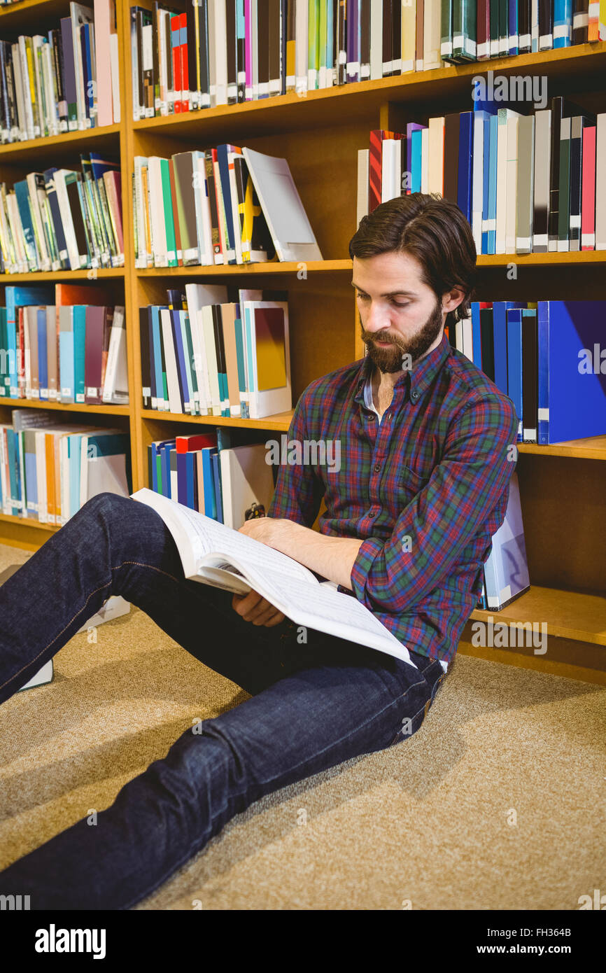 Student reading book in library on floor Stock Photo - Alamy