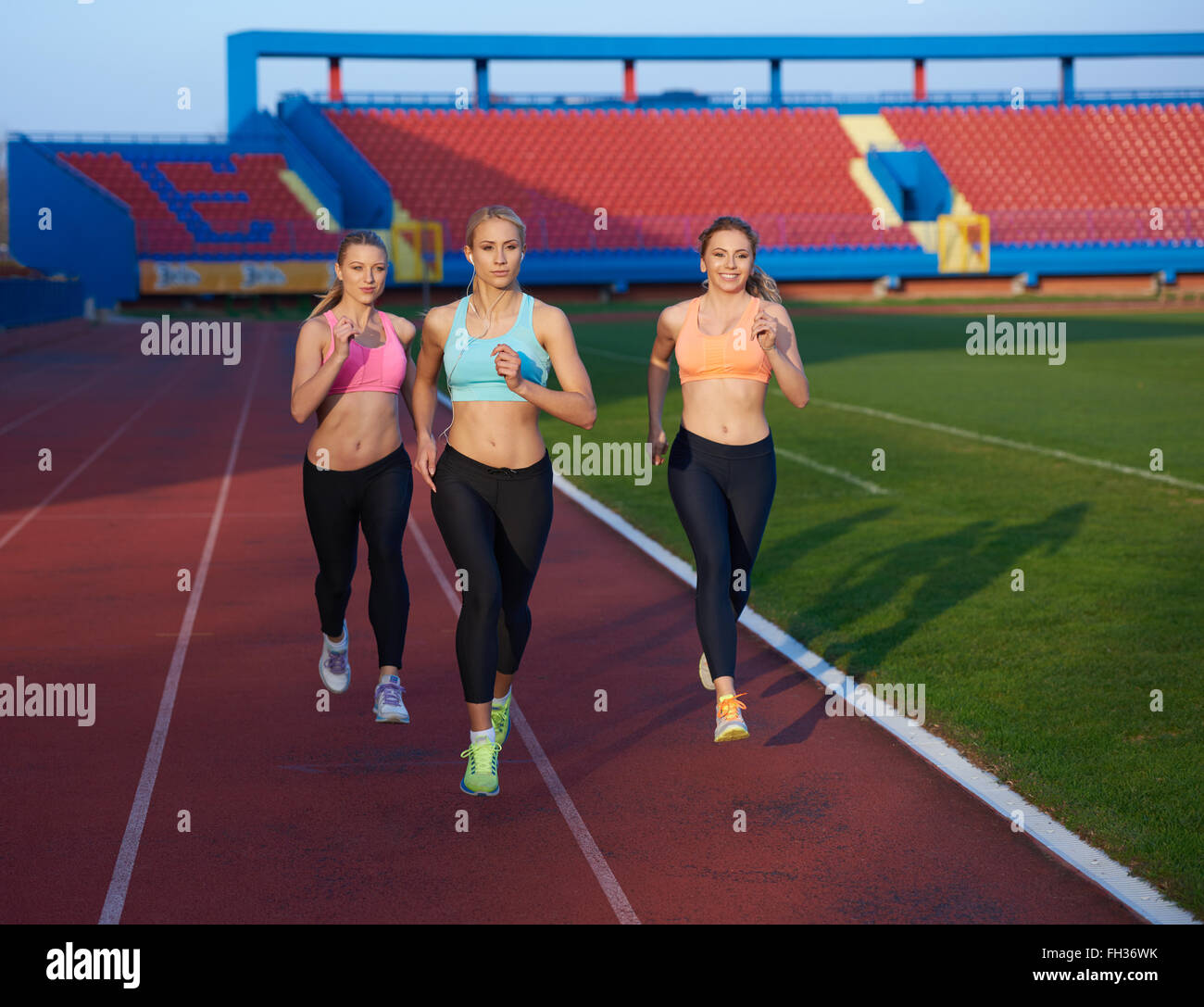 athlete woman group running on athletics race track Stock Photo - Alamy