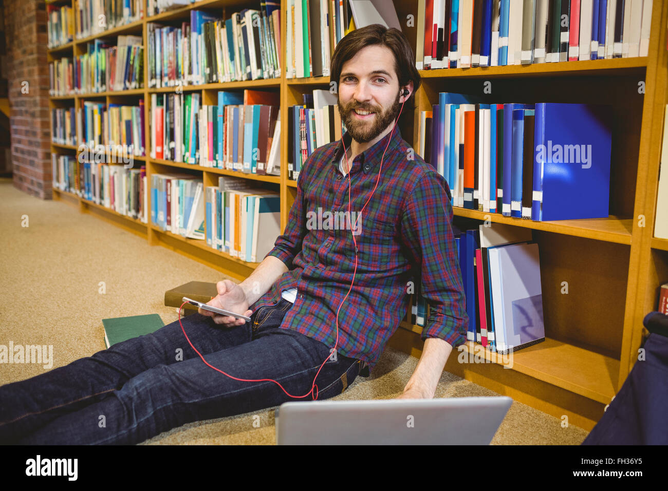 Student using phone in library on floor Stock Photo - Alamy